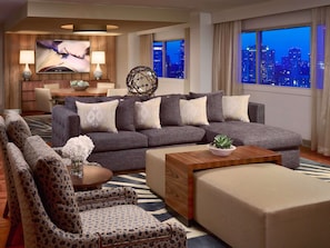 Uma sala de estar moderna com sofá modular, mesa de centro e televisão.