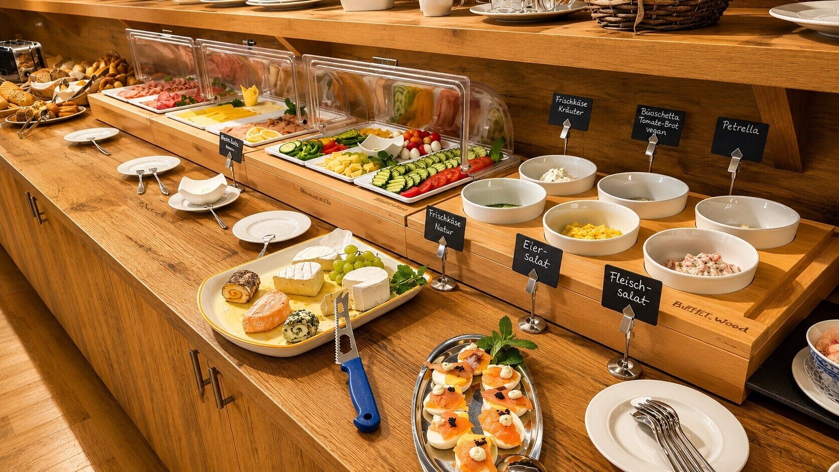 Buffet com diversos alimentos e etiquetas em ambiente de madeira.