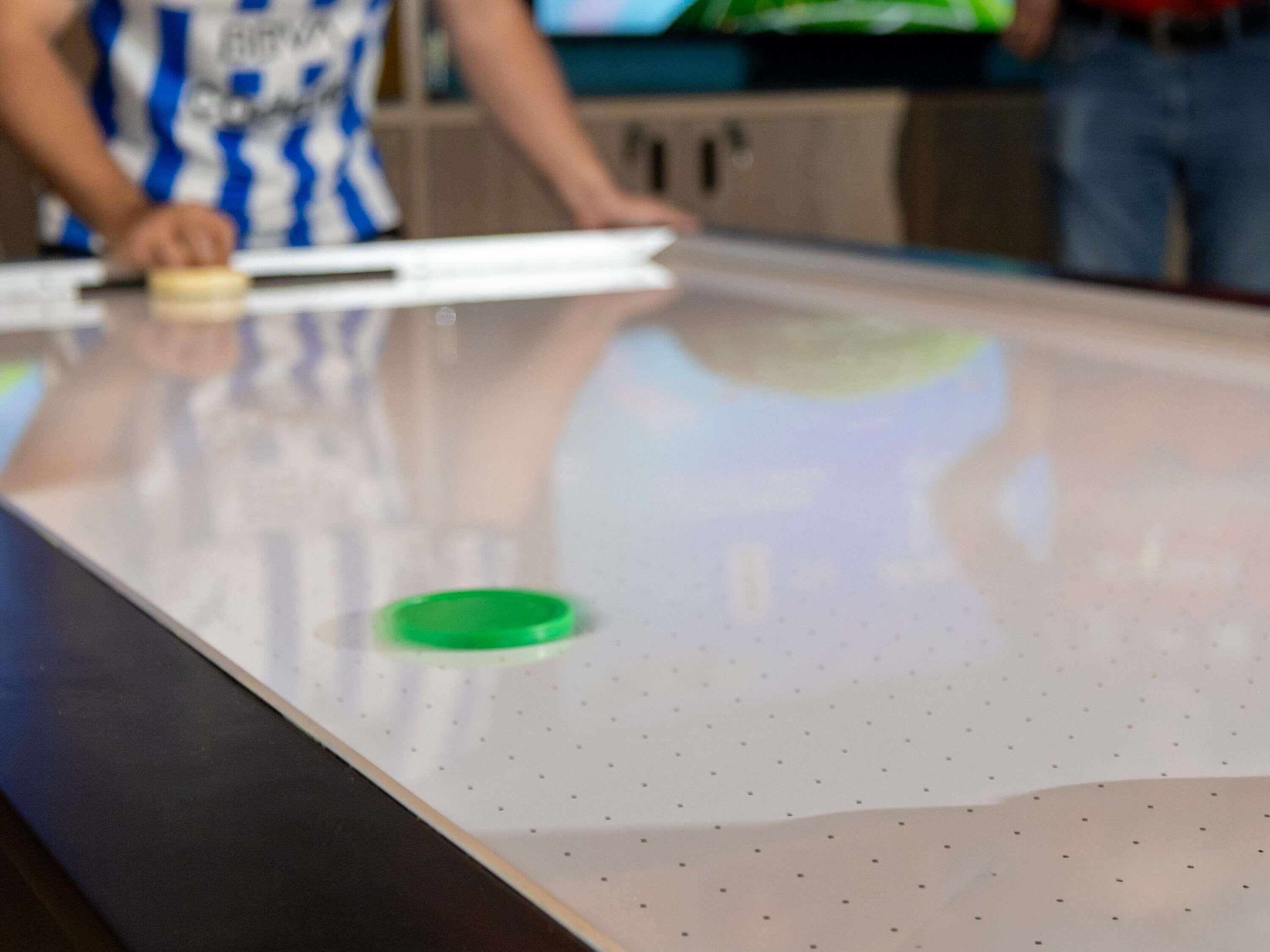 Uma mesa de bilhar com uma bola verde e um taco branco.