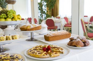 Uma mesa de buffet com diversos doces e frutas.