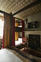 Um quarto com uma cama beliche, lareira, televisão e tapete estampado.