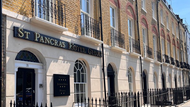 Uma fileira de edifícios de tijolo tradicionais com uma placa indicando 'St Pancras Hotel'.
