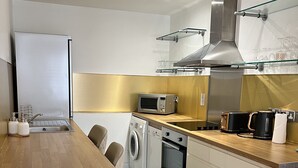 Uma cozinha moderna com bancada de madeira, eletrodomésticos de aço inoxidável e prateleira de vidro.