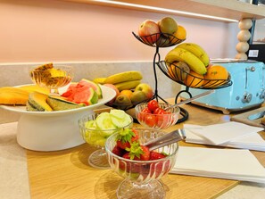 Uma bancada de cozinha com frutas variadas e uma torradeira antiga.