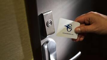 Mão segurando um cartão de visita com logotipo e texto, inserido em um leitor de cartão na porta.