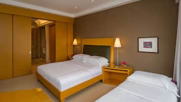 Quarto de hotel com cama, mesas de cabeceira, espelho e um quadro na parede.