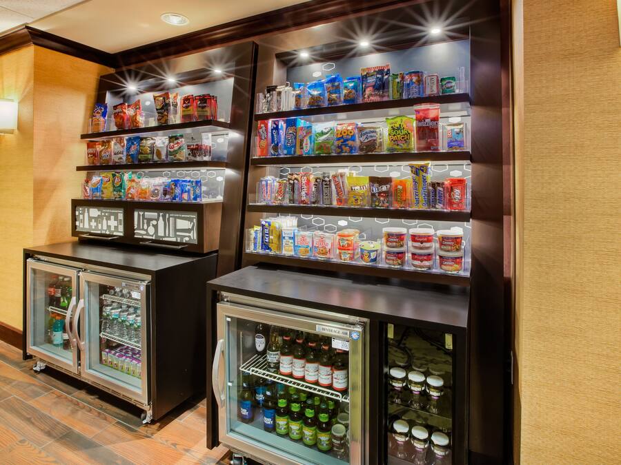 Área de máquinas de venda automática com lanches, bebidas e produtos refrigerados.