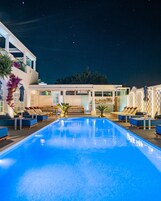 Uma área de piscina com espreguiçadeiras e um bar.
