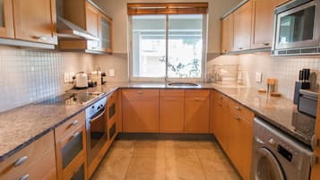 Apartamento superluxo, 1 quarto | Cozinha privada | Geladeira grande, micro-ondas, fogão, cooktop