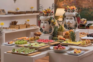 Uma mesa de buffet com diversas frutas e doces.