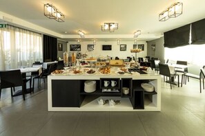 Uma cozinha moderna com ilha central, área de refeições e grandes janelas.