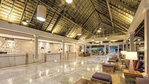 Um hall amplo com teto alto, piso de mármore e áreas de estar.