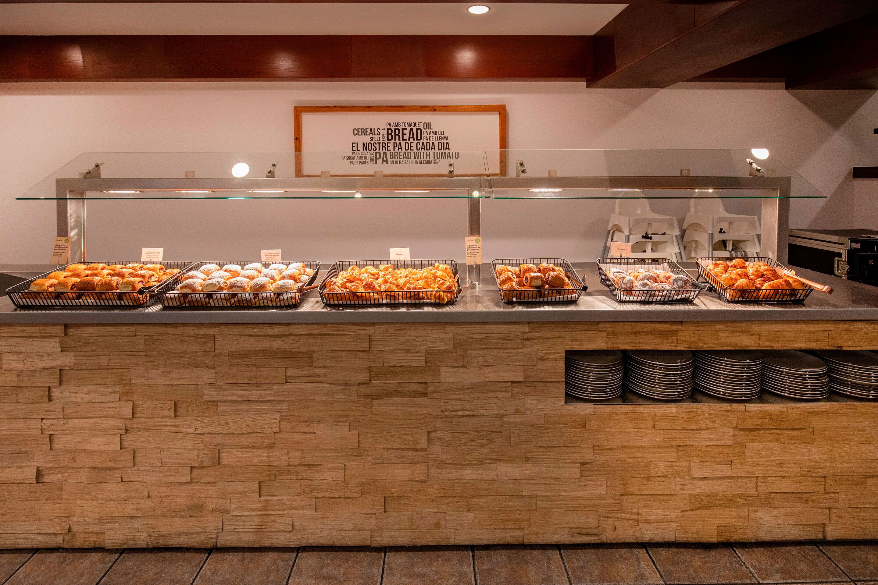 Vitrine de pastelaria com diversos pães e bolos.