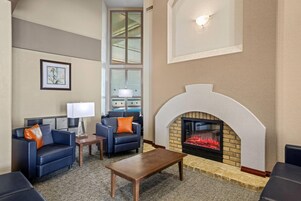 Um hall com lareira, área de estar e um quadro na parede.