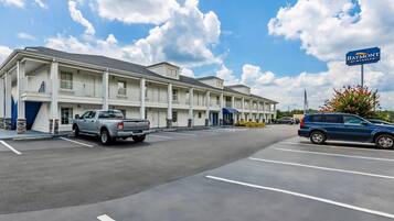 Um motel com uma fileira de quartos, um estacionamento e a placa da Baymont by Wyndham.