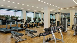 Academia moderna com esteiras, elípticos e aparelhos de musculação.