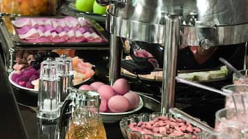 Buffet com diversos alimentos e uma grande estrutura em cúpula de metal.