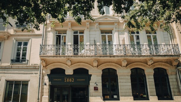 Um edifício histórico com varanda e uma placa com a inscrição "1882".