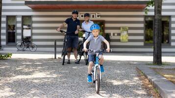 Uma rua de paralelepípedos com ciclistas e um edifício ao fundo.