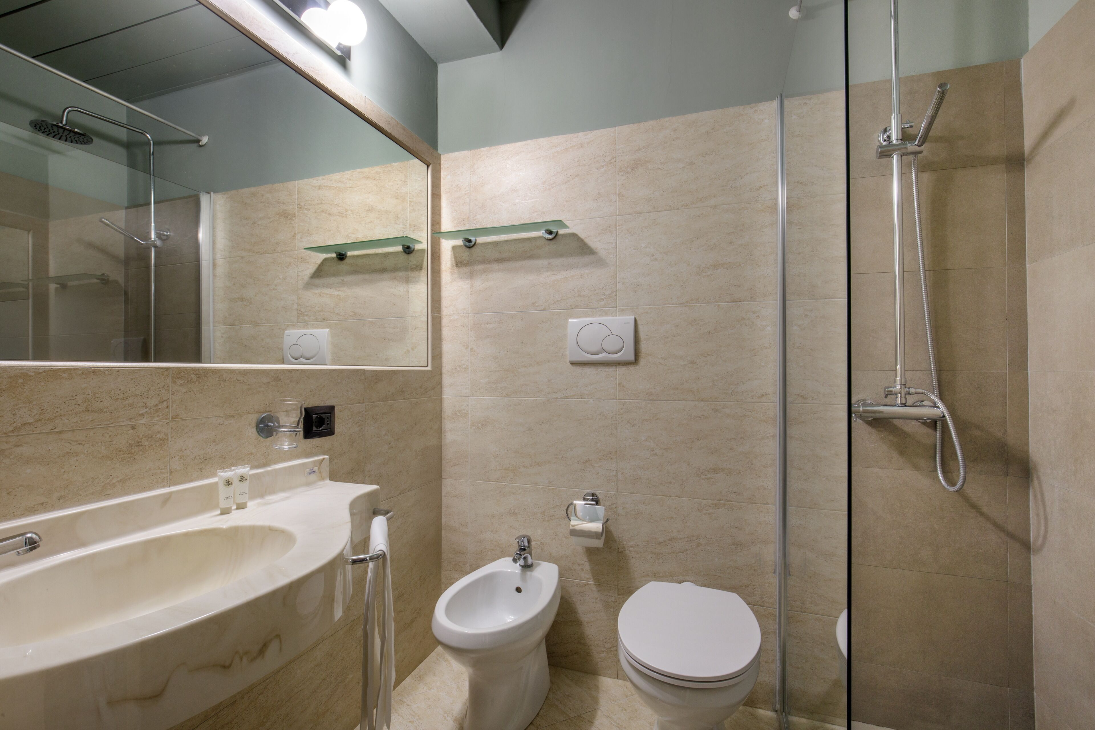 Uma casa de banho moderna com banheira, bidé, sanita e cabine de duche de vidro.