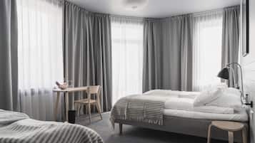 Quarto de hotel moderno com uma cama, uma escrivaninha e uma cadeira.