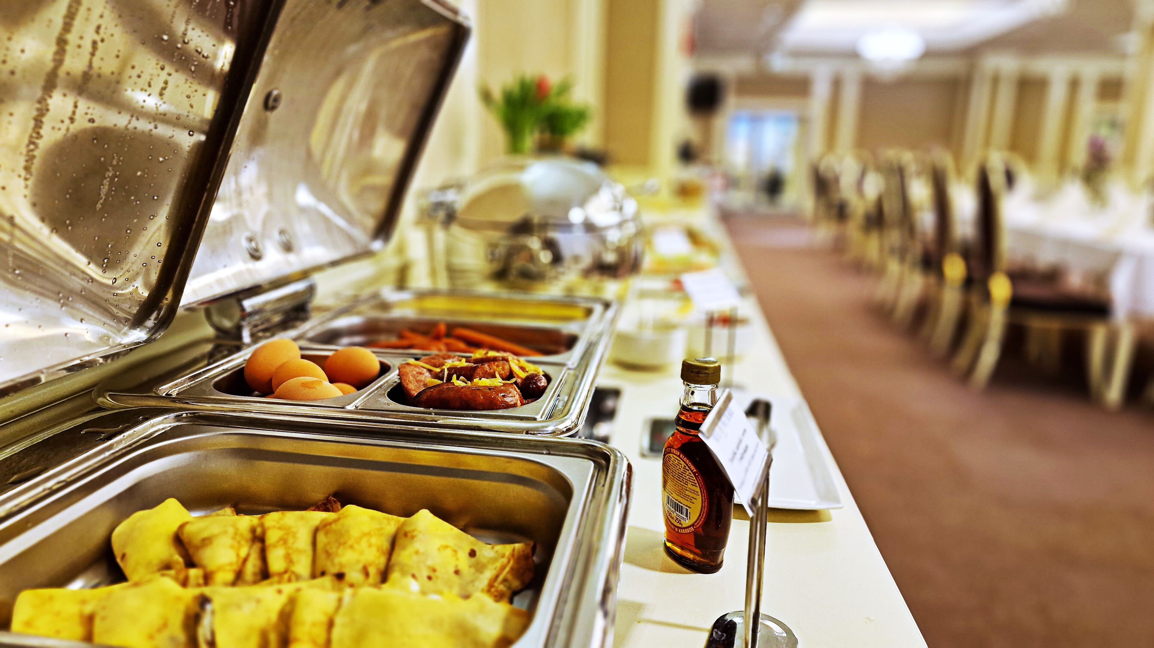 Buffet com diversos alimentos e uma garrafa de molho.