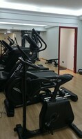 Uma academia com bicicletas ergométricas e esteiras.