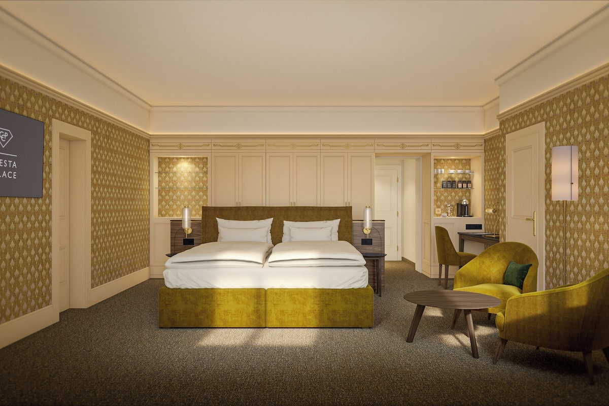 Quarto de hotel com uma cama grande, uma mesa, uma cadeira e uma pequena mesa.