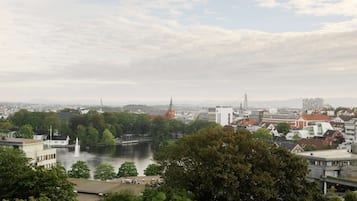 Paisagem urbana com um rio, edifícios e uma torre de igreja imponente.