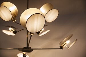Um candelabro com várias luminárias esféricas e uma cobertura circular central.