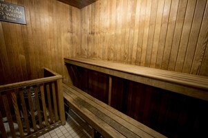 Uma sauna de madeira com bancos e uma placa indicando que é uma sauna e sauna de água.
