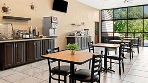 Um café moderno com balcão, máquinas de café e área de estar.