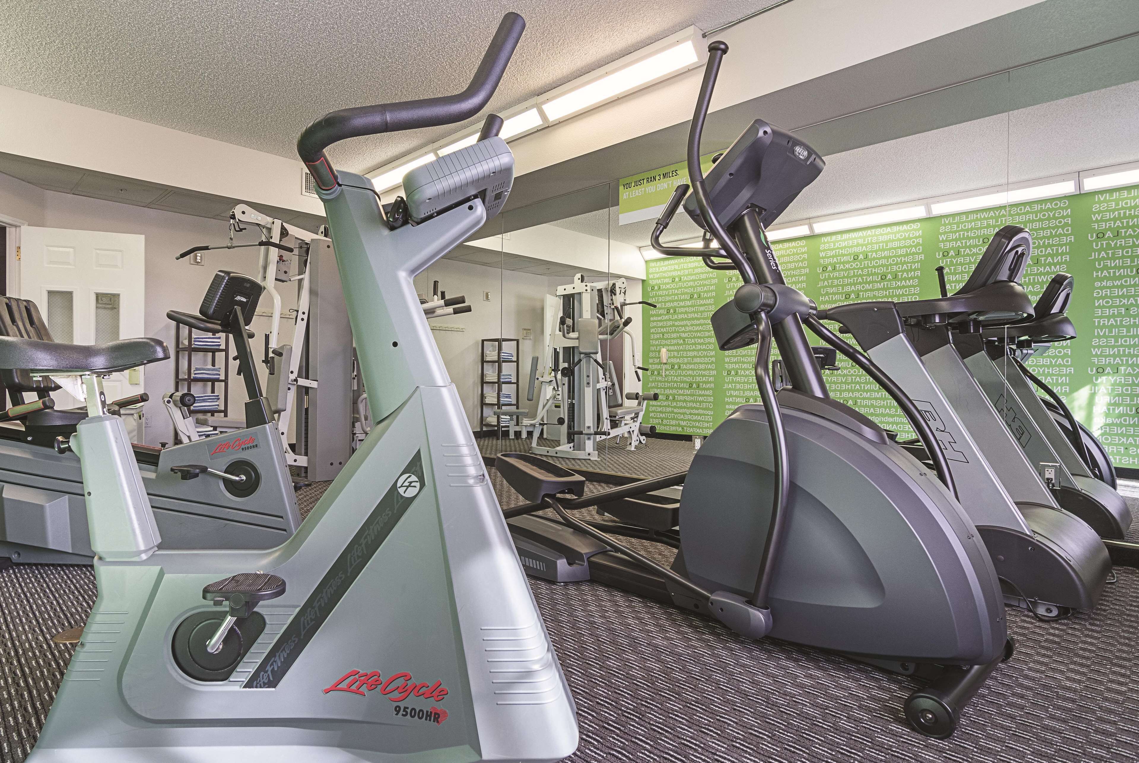 Academia com bicicletas ergométricas, esteiras e aparelhos de musculação.