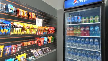 Máquina de vendas abastecida com diversos lanches e bebidas, incluindo Doritos, Lay's e água Aquafina.