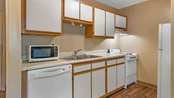 Um frigorífico/congelador grande, um micro-ondas, uma placa de cozinha