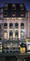 Um hotel de vários andares com fachada clássica, grandes janelas e entrada imponente.