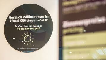 Placa de boas-vindas do Hotel Göttingen-West, com um ícone de sol e texto em alemão.