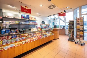 Área de Kasse e Recepção com diversos snacks, lembranças e uma grande janela que proporciona luz natural.