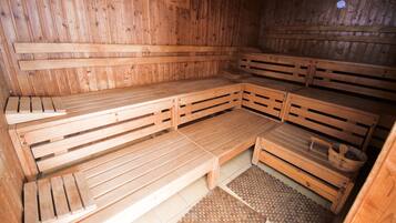 Uma sauna com bancos de madeira e uma pequena mesa com uma tigela.