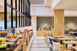 Disposição de buffet com diversos alimentos, mobiliário de madeira e design de interiores moderno.