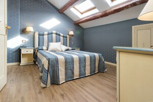 Quarto com cama, mesas de cabeceira, luminária e guarda-roupa.