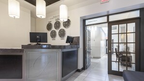 Uma área de recepção com balcão de mármore, vários relógios e design de interiores moderno.
