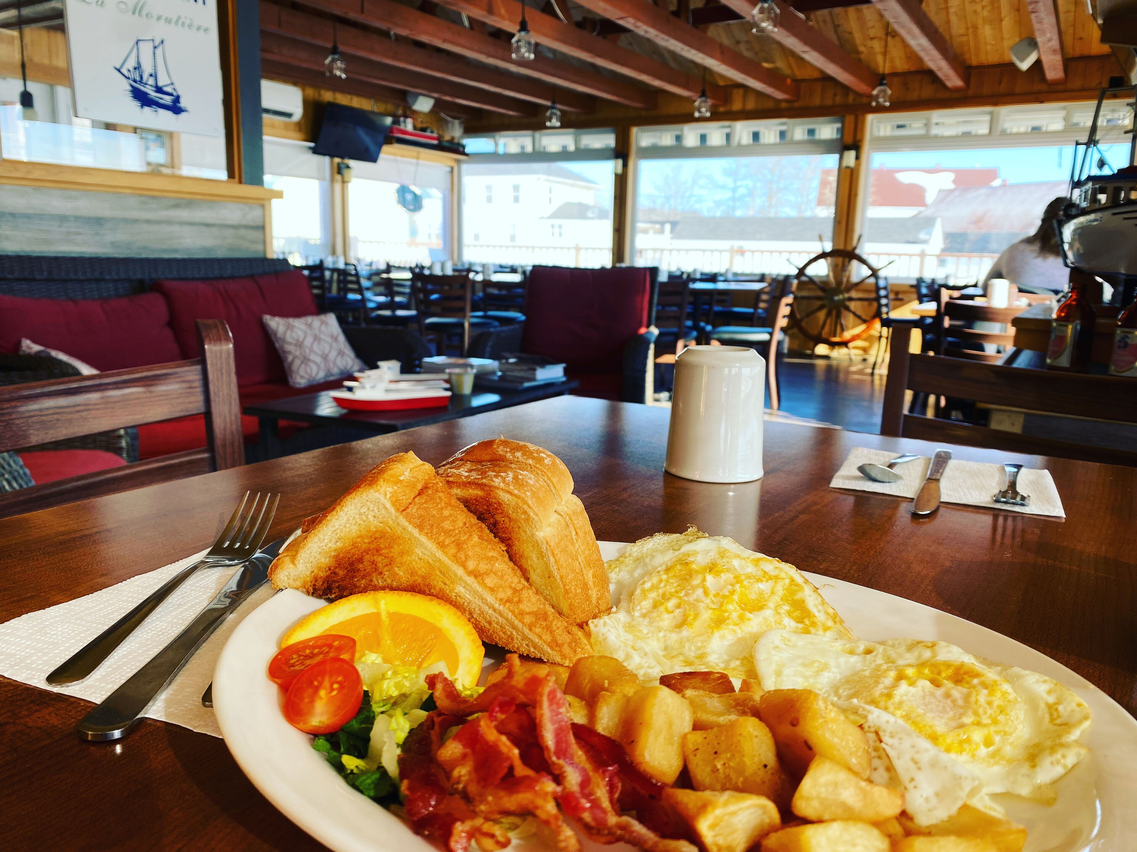 Prato de café da manhã com torradas, ovos, bacon e batatas.