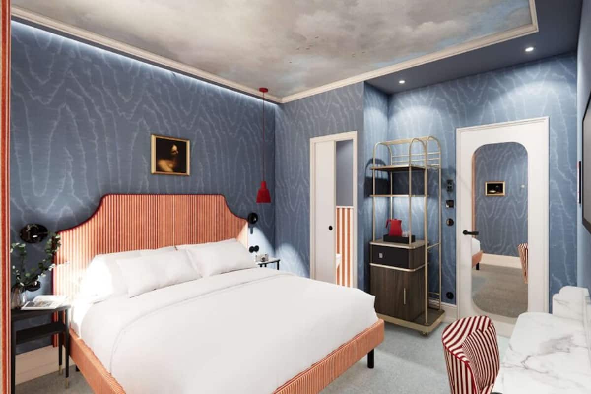 Quarto com cama, mesa de cabeceira, luminária, guarda-roupa e espelho.