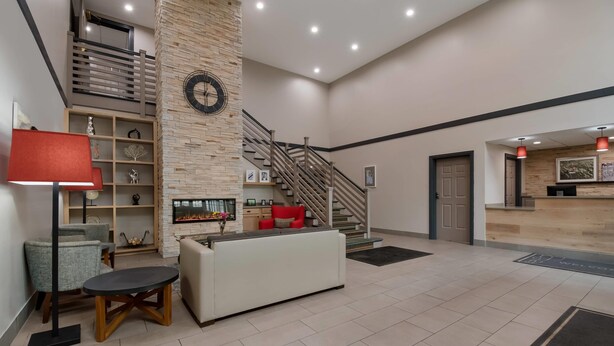 Um hall amplo com escada, balcão de recepção e área de estar com sofá e cadeiras.