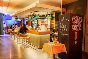 Uma área de bar com banquetas, balcão e lousa com texto.