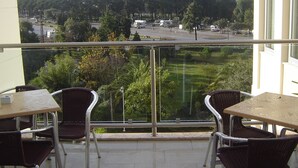 Uma varanda com vista para uma igreja e vegetação.