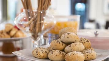 Um prato de pães redondos com sementes sobre uma mesa.