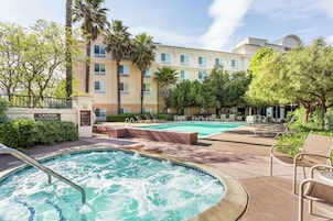 Um hotel com área de piscina, incluindo hidromassagem e espreguiçadeiras.