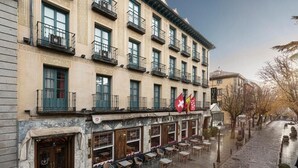 Hotel com área externa para sentar, várias varandas e bandeiras.